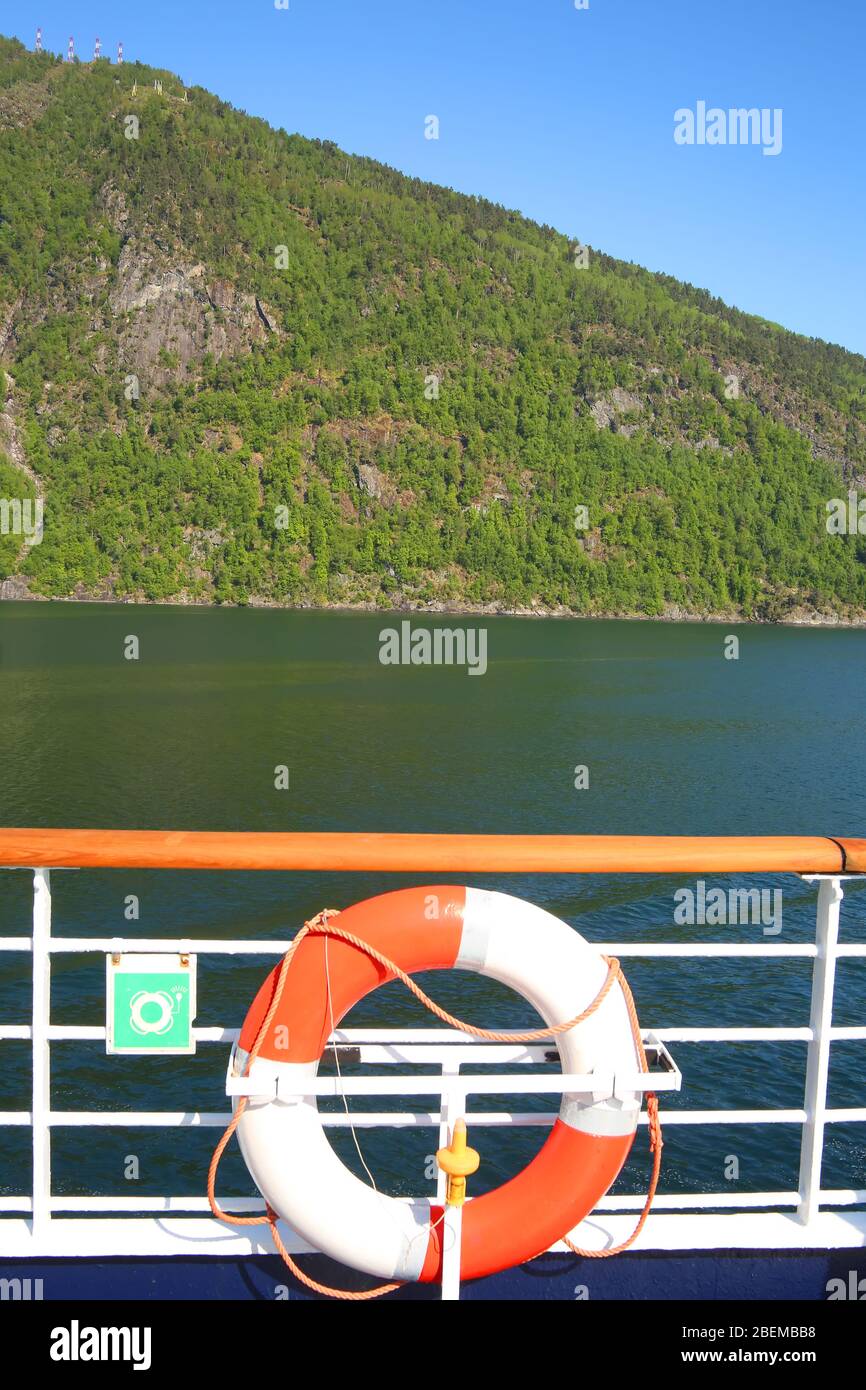 Deck of a ship & life ring as it cruises down the Sognefjord or ...