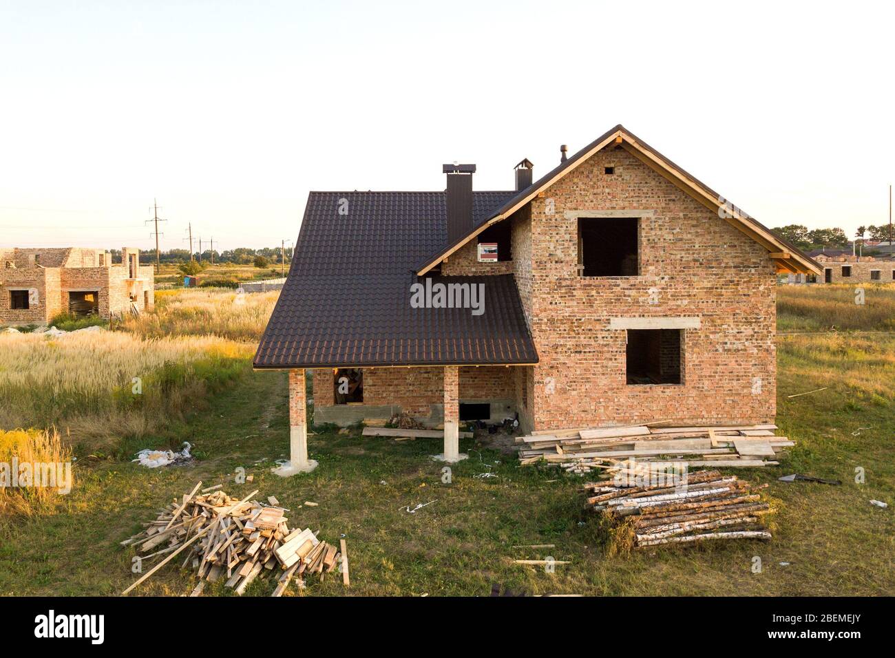 Unfinished brick house with wooden roof structure covered with metal ...
