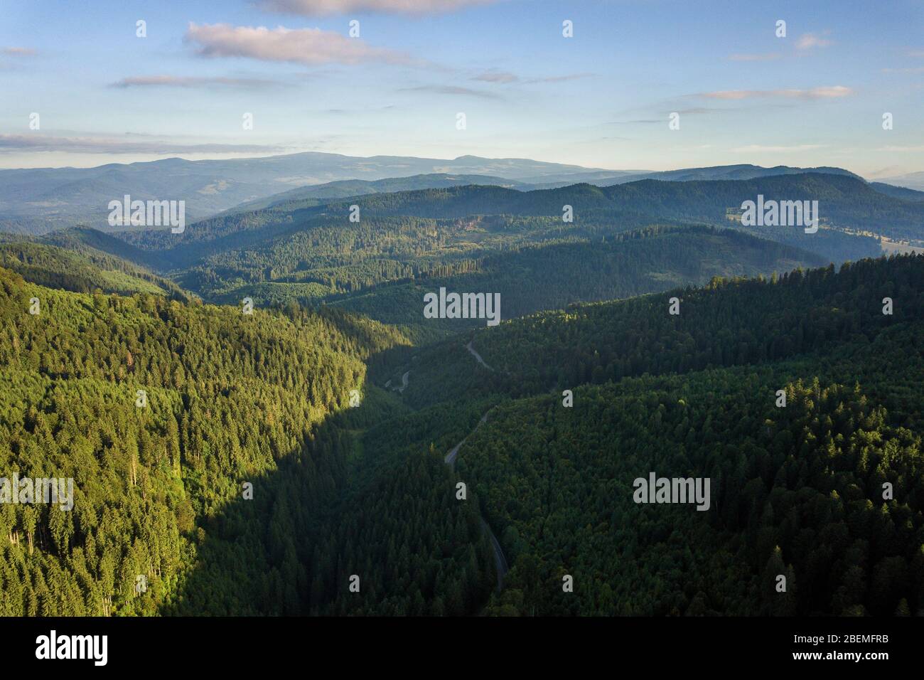 Aerial view of winding road in high mountain pass trough dense green ...