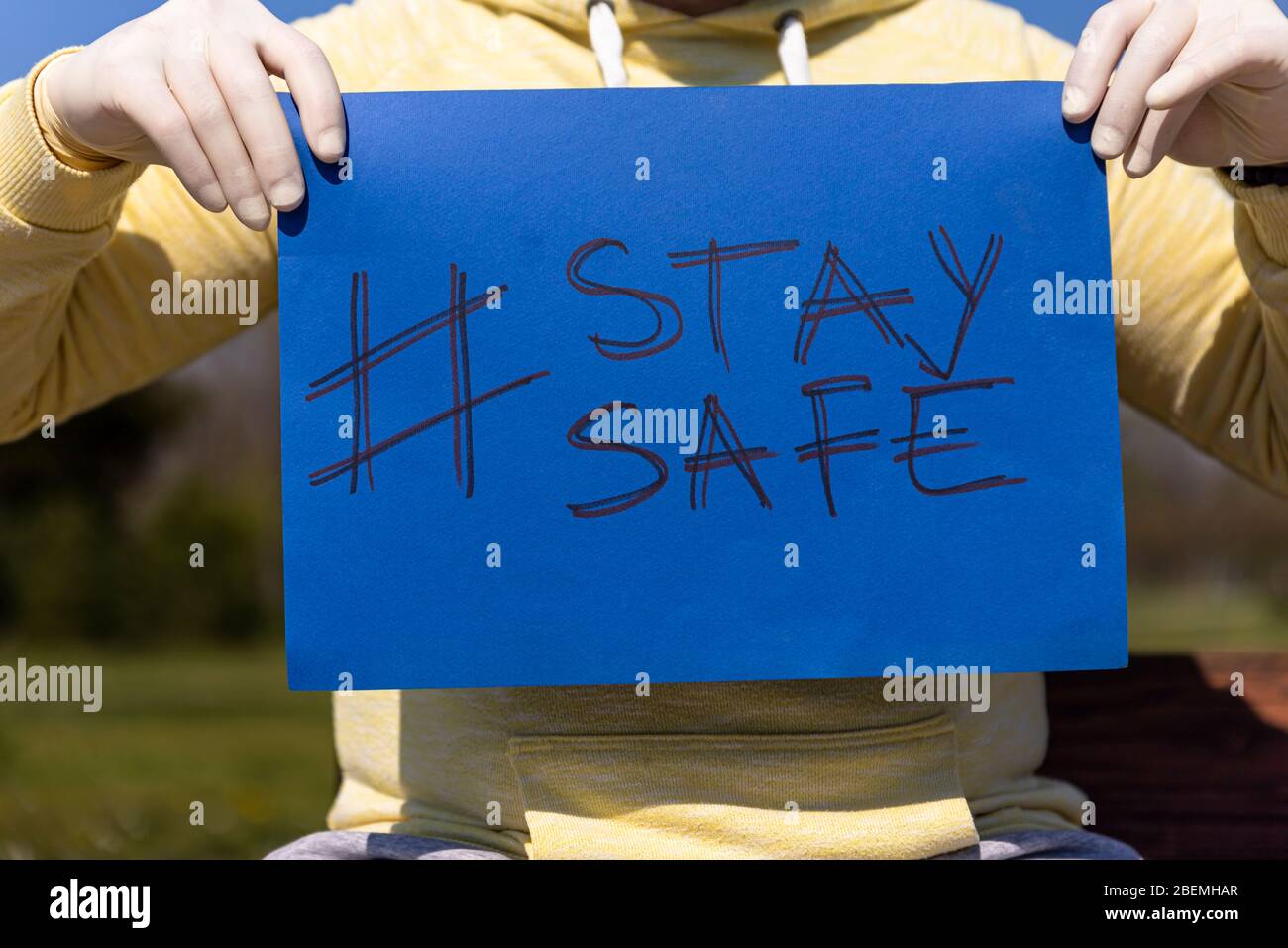 Stay safe sign on blue chroma key paper held by a man in surgical ...