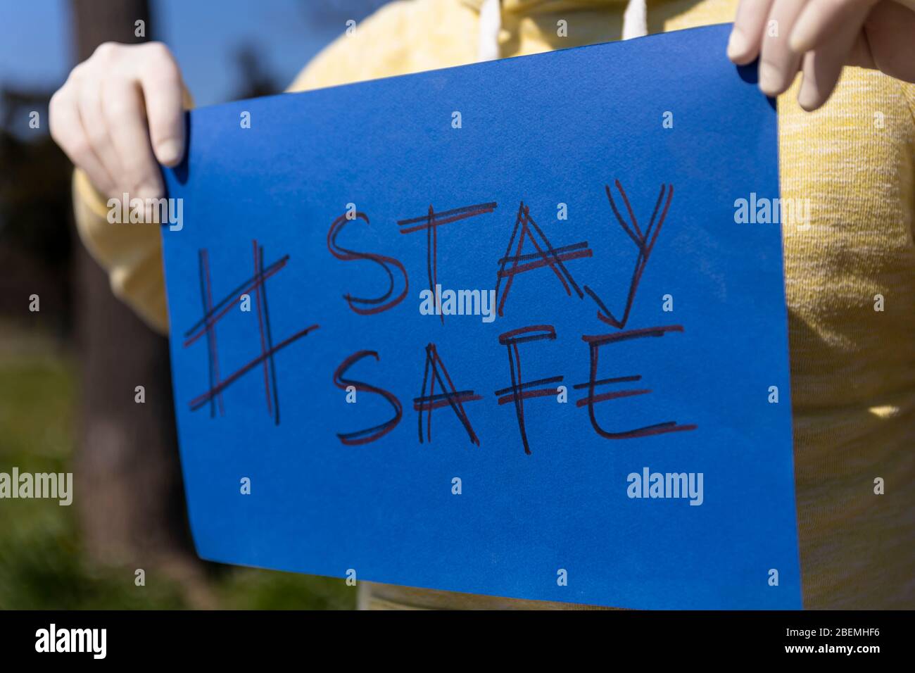 Stay safe sign on blue chroma key paper held by a man in surgical ...