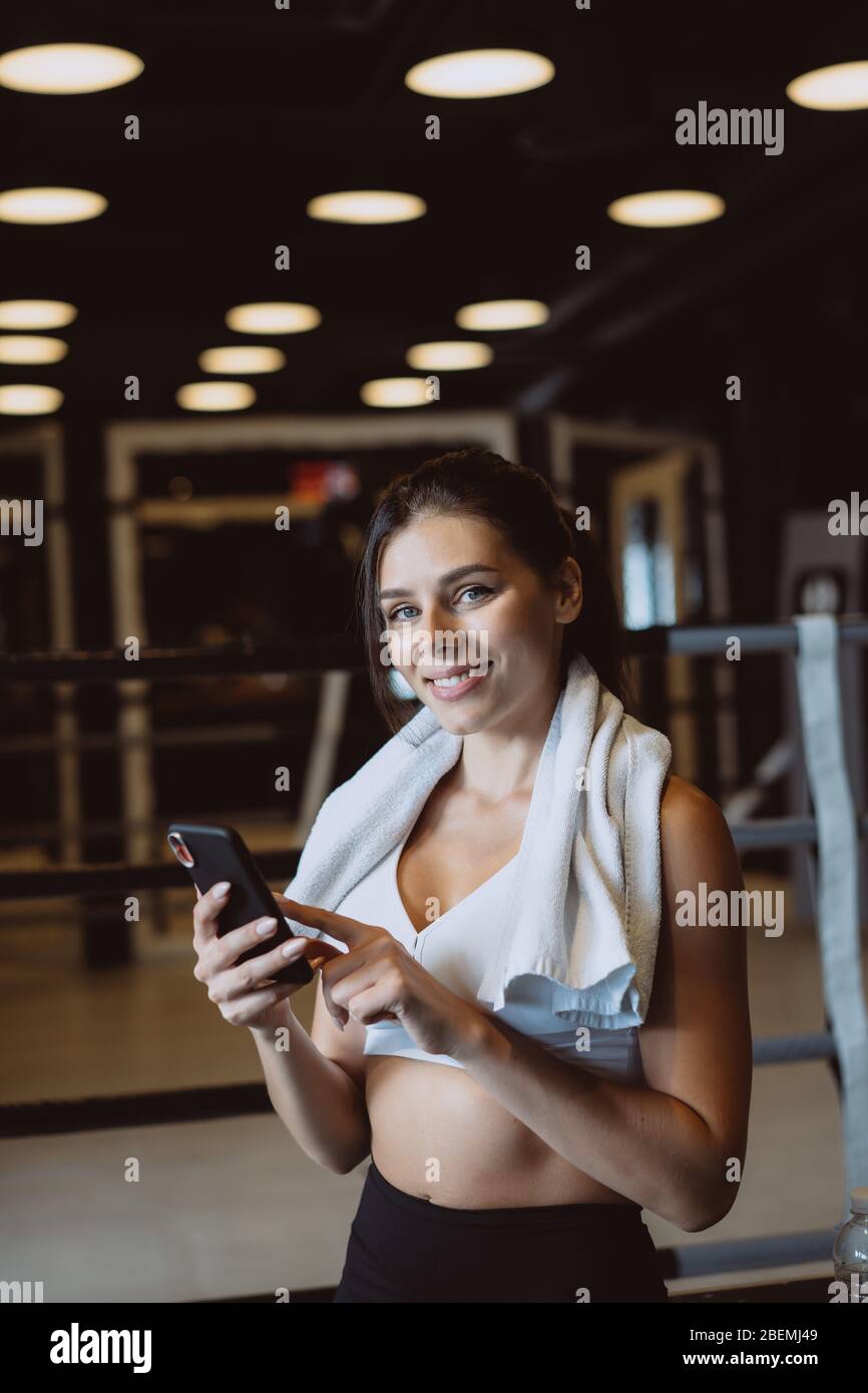 Girl texting while taking a break in a gym. Reads a message Stock Photo ...