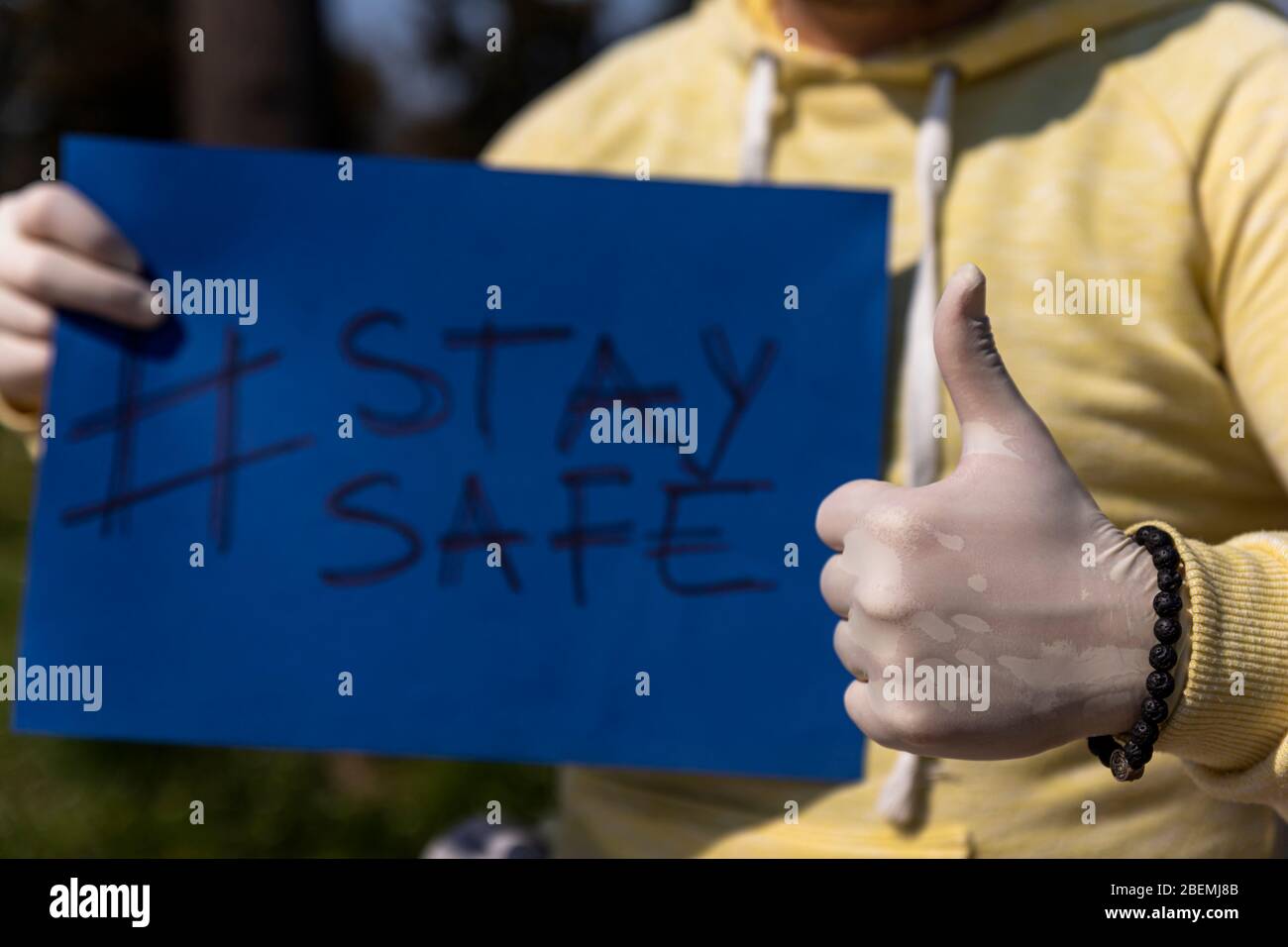 Stay safe sign on blue chroma key paper held by a man in surgical ...