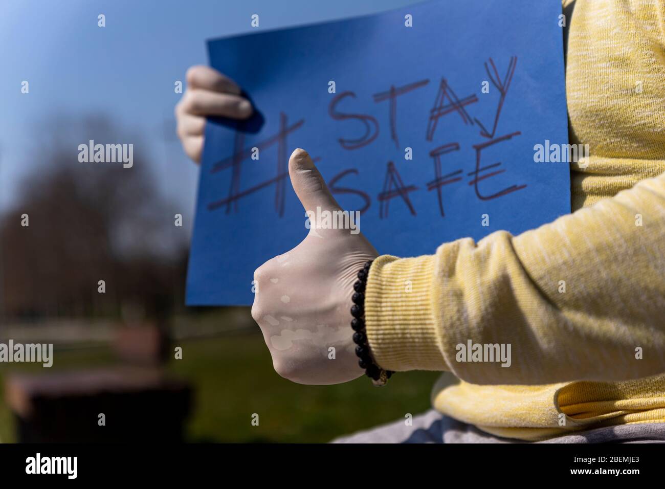 Stay safe sign on blue chroma key paper held by a man in surgical ...