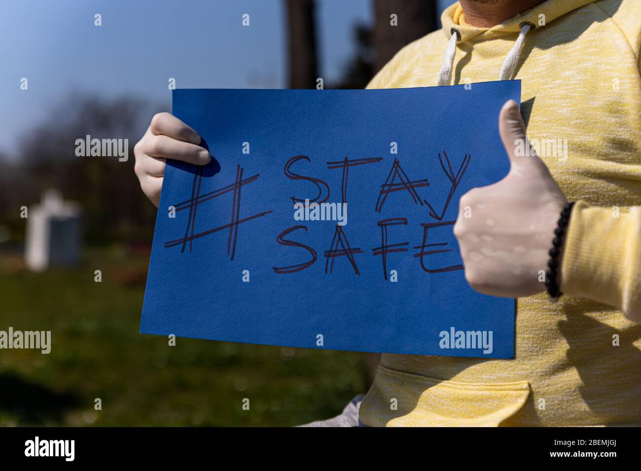 Stay safe sign on blue chroma key paper held by a man in surgical ...
