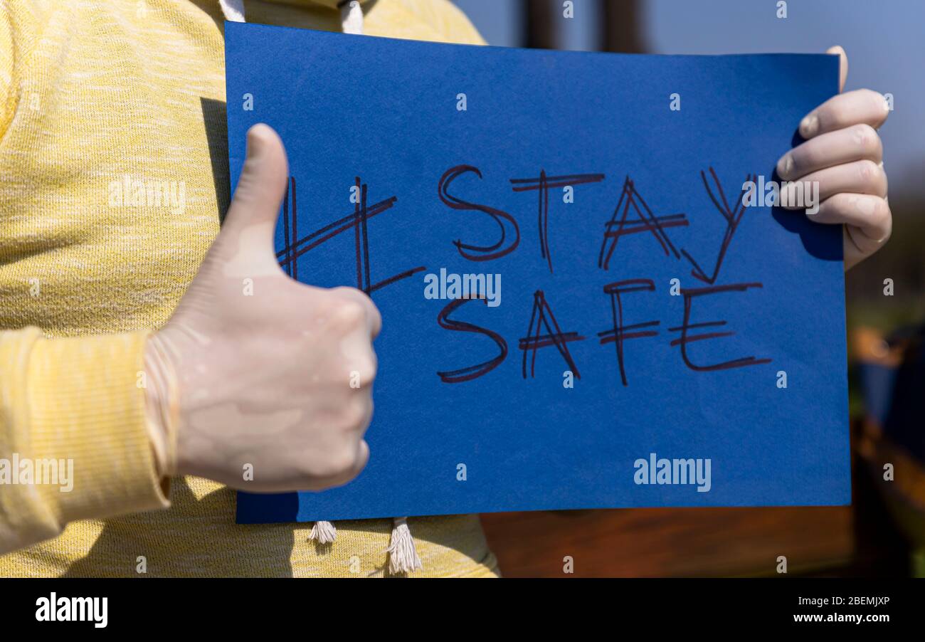 Stay safe sign on blue chroma key paper held by a man in surgical ...