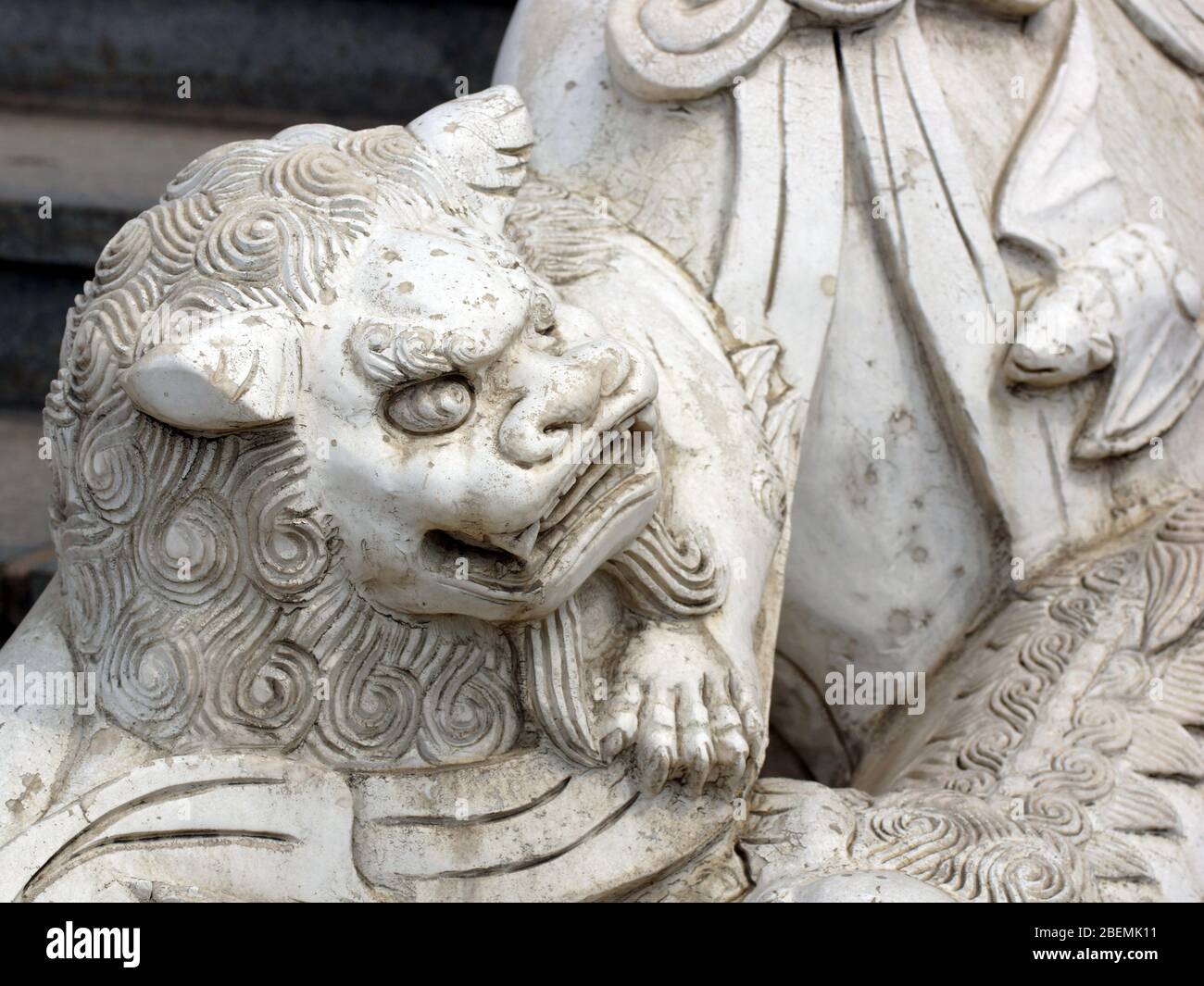 Chinese mythical lion and bat carved in stone. Jade Buddha Park, Anshan ...