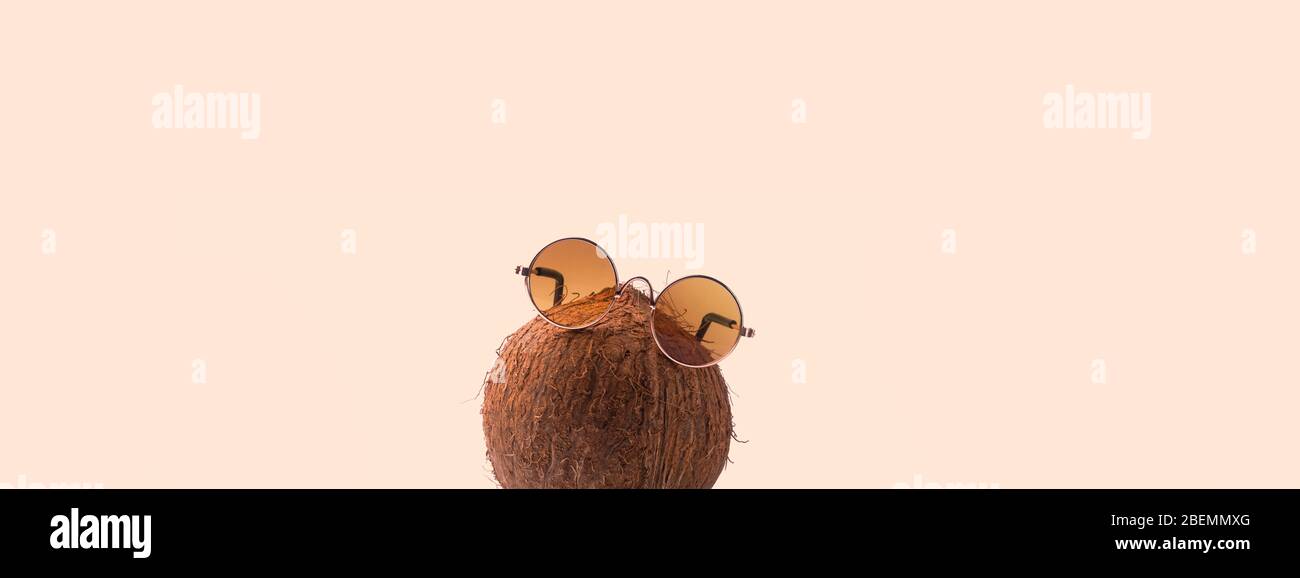 Coconuts are wearing sunglasses over pink background. Concept vacation ...