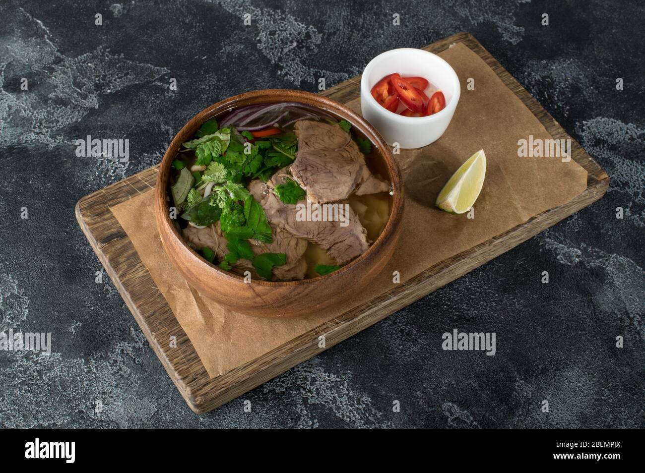 Vietnamese pho bo soup in a wooden bowl on dark background. Asian ...