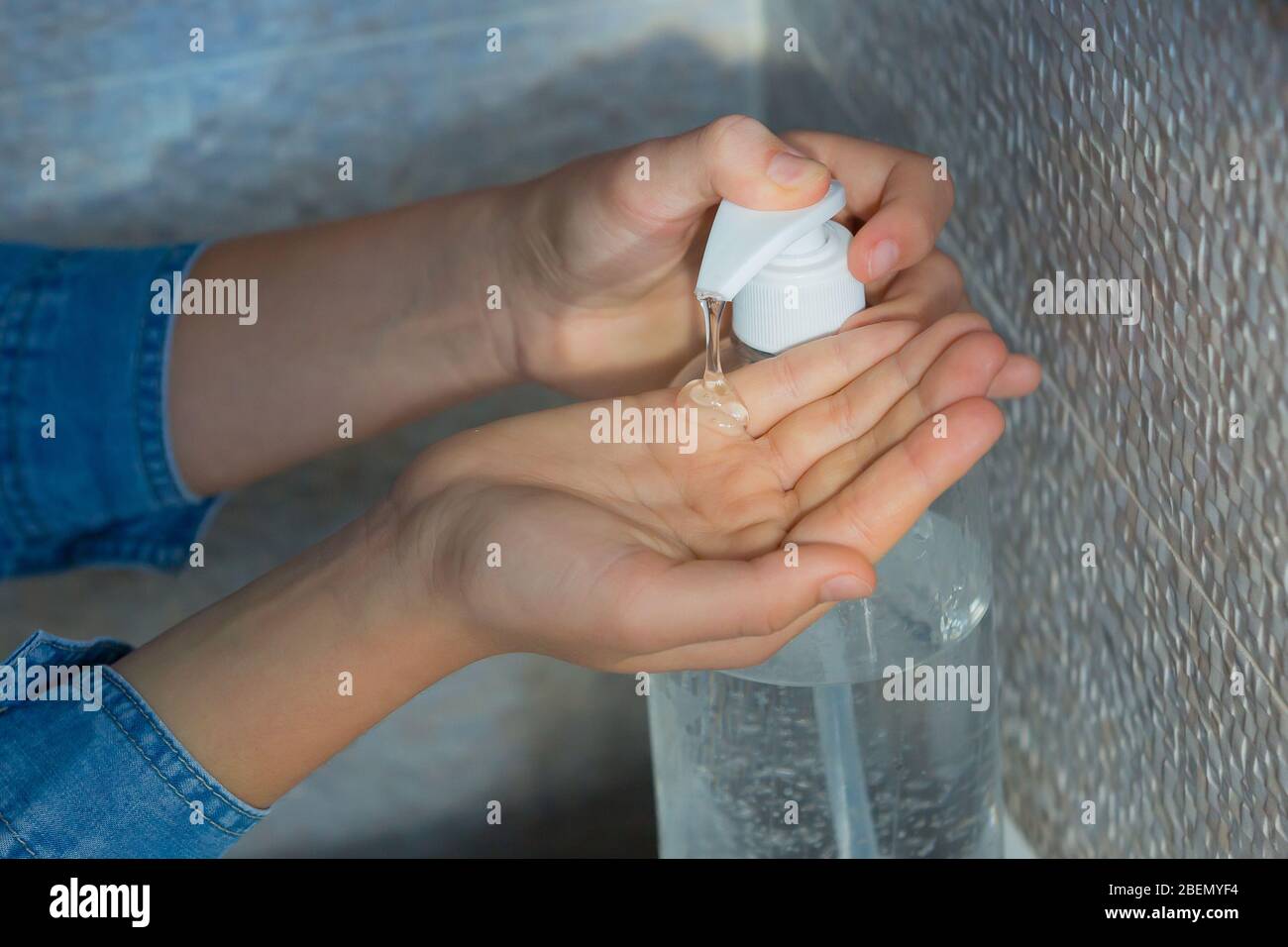 Young girl washing hands with alcohol gel or antibacterial soap ...
