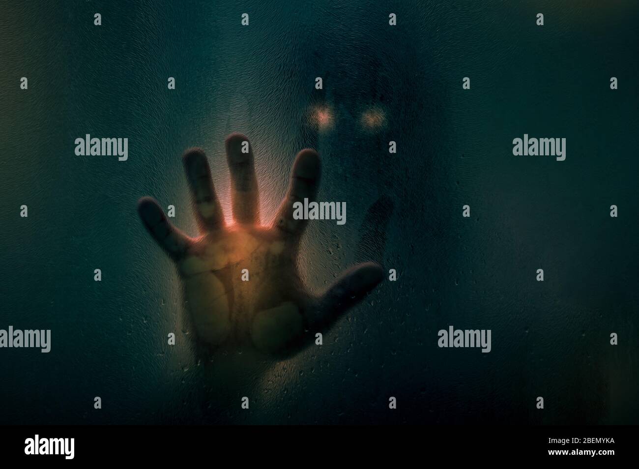 Horror scene of a man with bloody hand against wet shower glass. Toned ...
