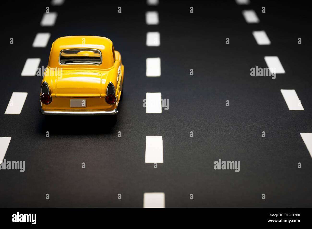 Rear view of a Yellow toy car on an asphalt road Stock Photo - Alamy