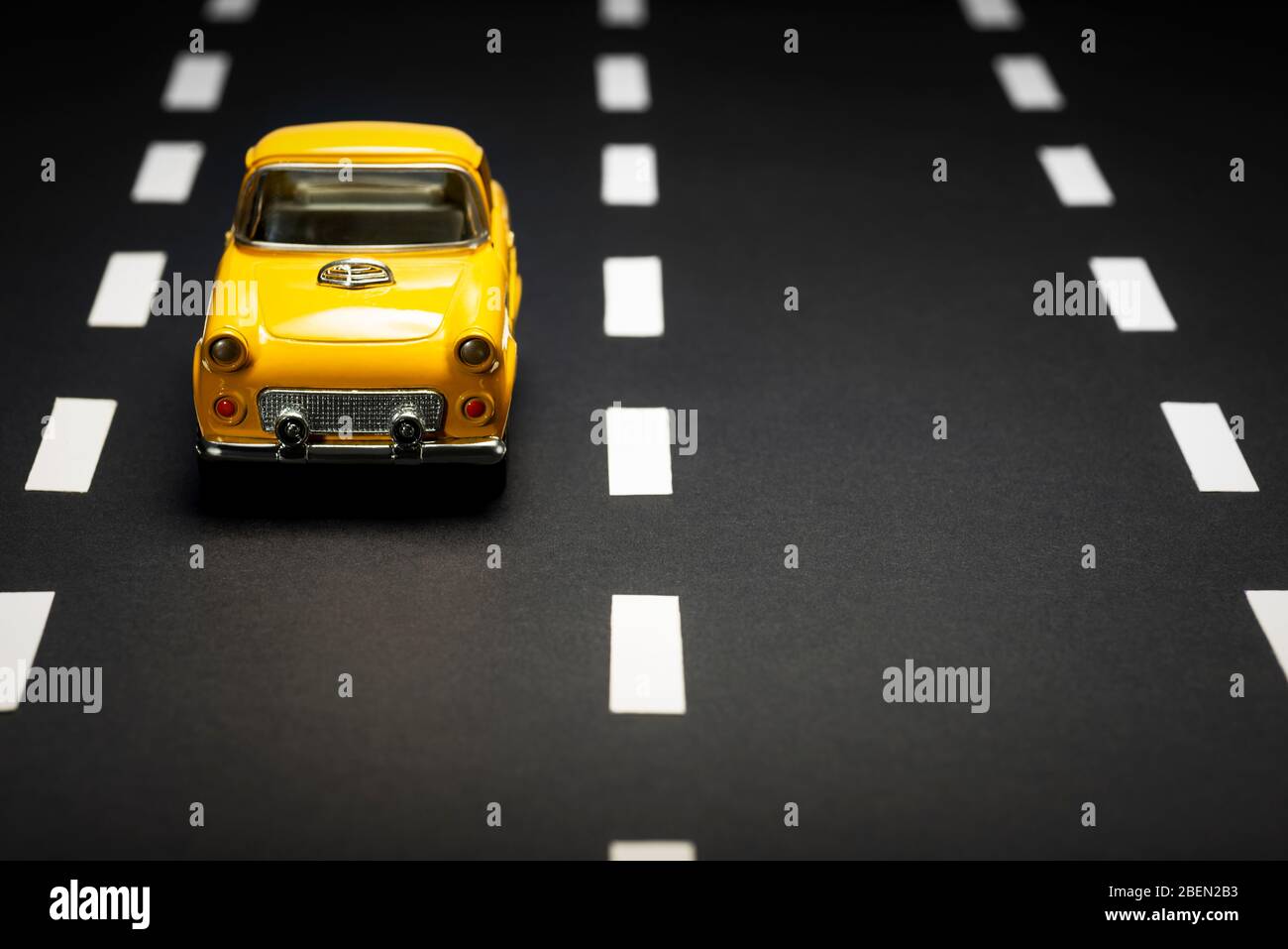 Front view of a Yellow toy car on an asphalt road Stock Photo - Alamy