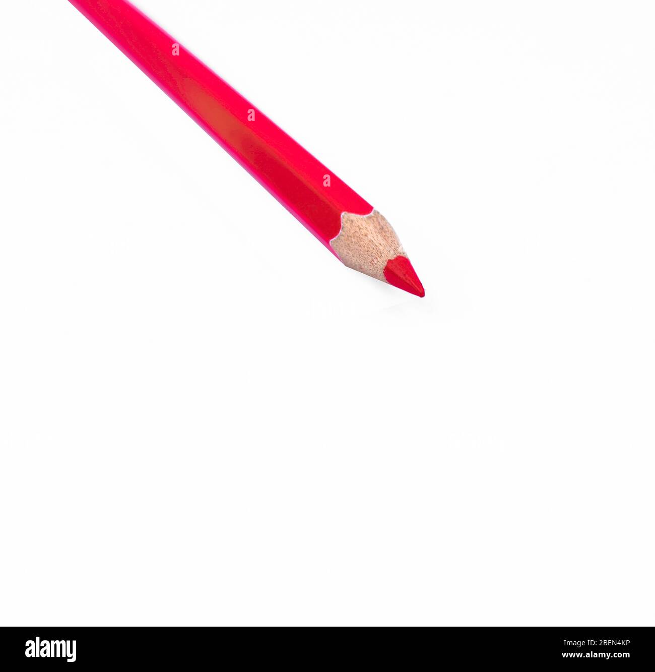 One single red colored wood pencil crayon placed on an isolated white ...