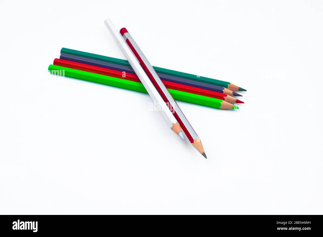 Two different colored wood pencil crayon placed on top of four pencil ...