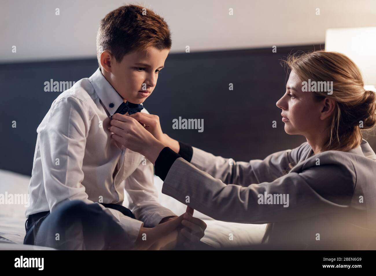 A Mother helping her son to get ready for school, buttoning up his shirt Stock Photo - Alamy