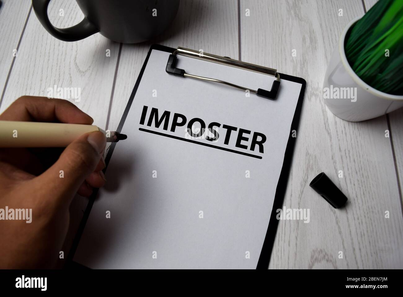Imposter write on clipboard isolated on Office Desk Stock Photo - Alamy
