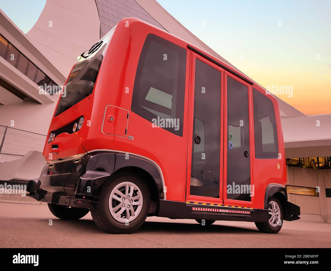 Bright red electric mini bus offering free transport to pedestrians ...