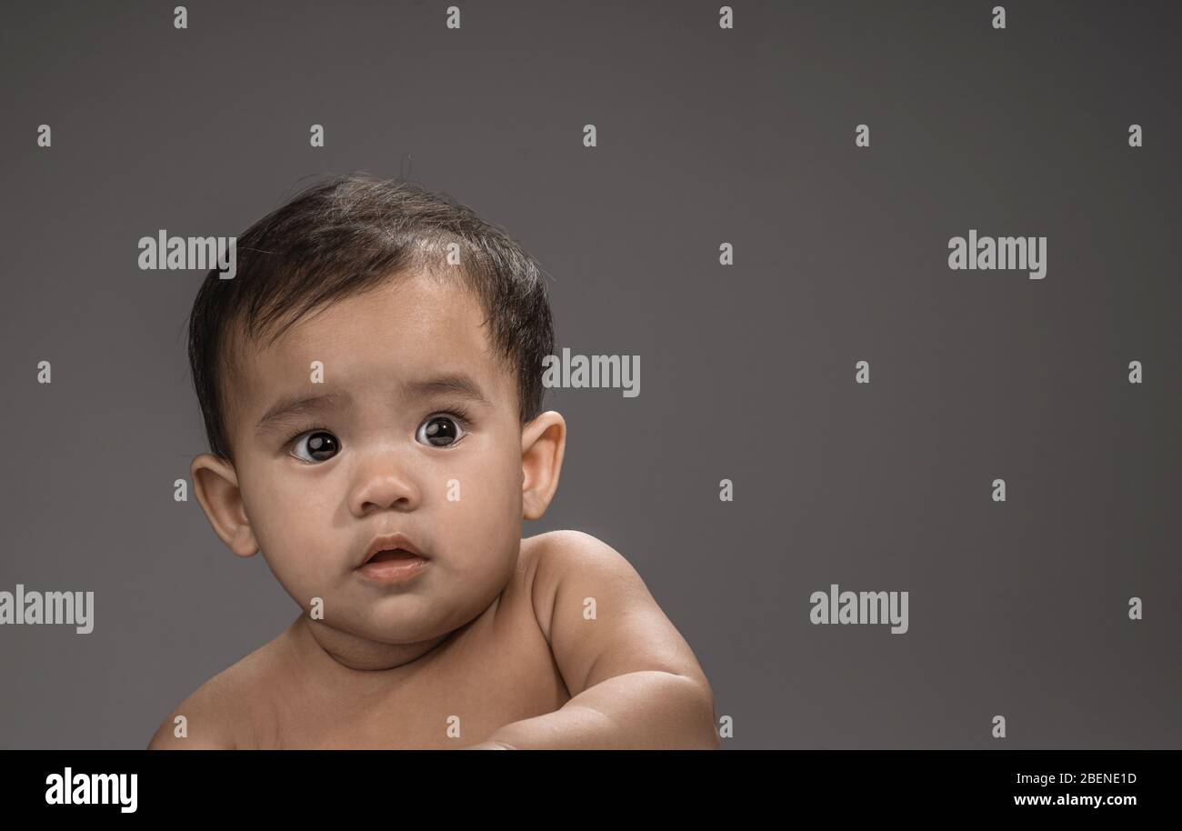 close up of baby face look up thinking over grey background Stock Photo ...