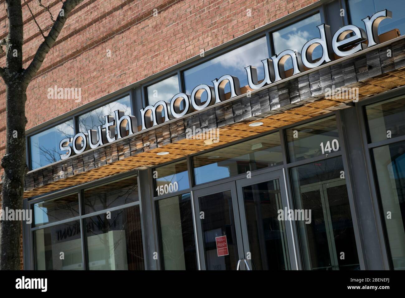 A logo sign outside of a South Moon Under retail store location in ...