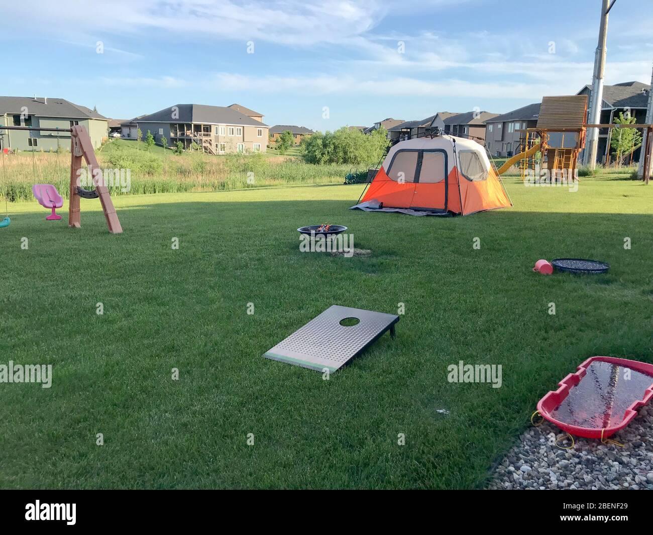 Backyard camping in town with tent, play ground, and fire pit Stock ...