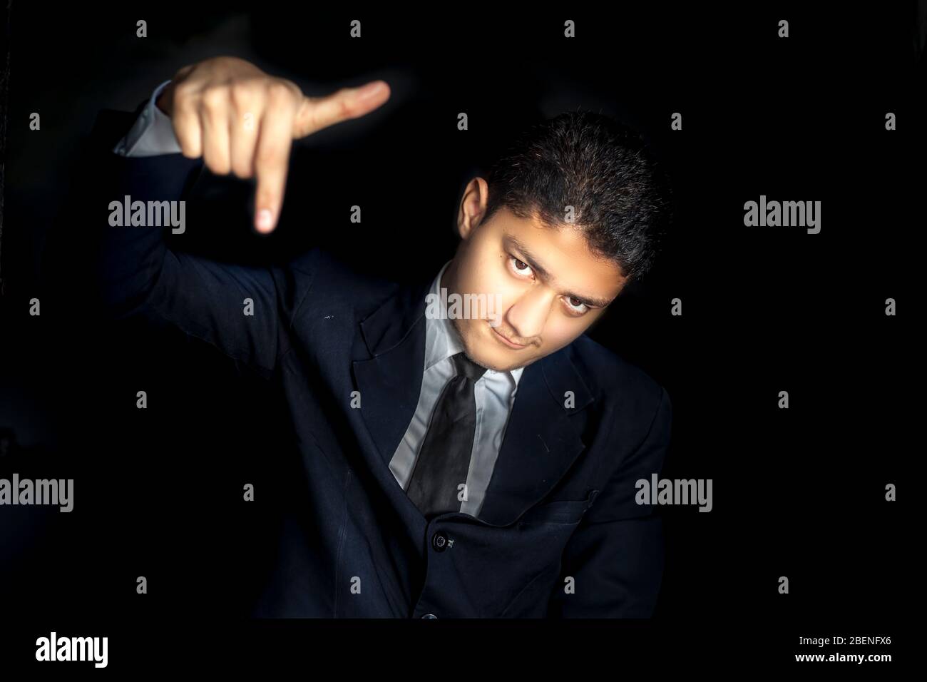 Portrait shot of an arrogant businessman posing on a black colored ...