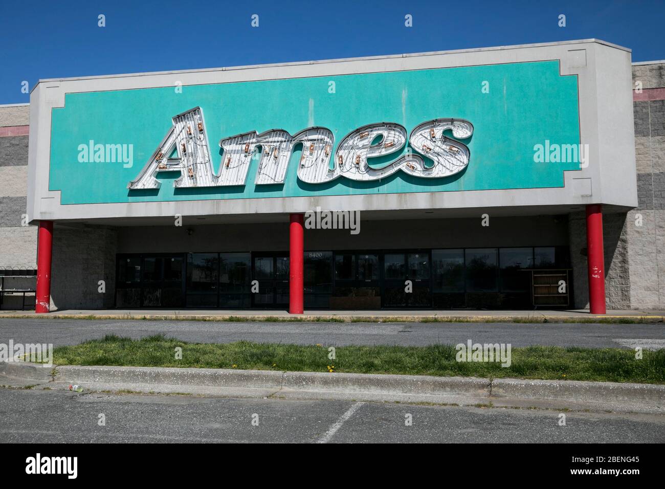 A logo sign outside of a closed and abandoned Ames Department Stores ...