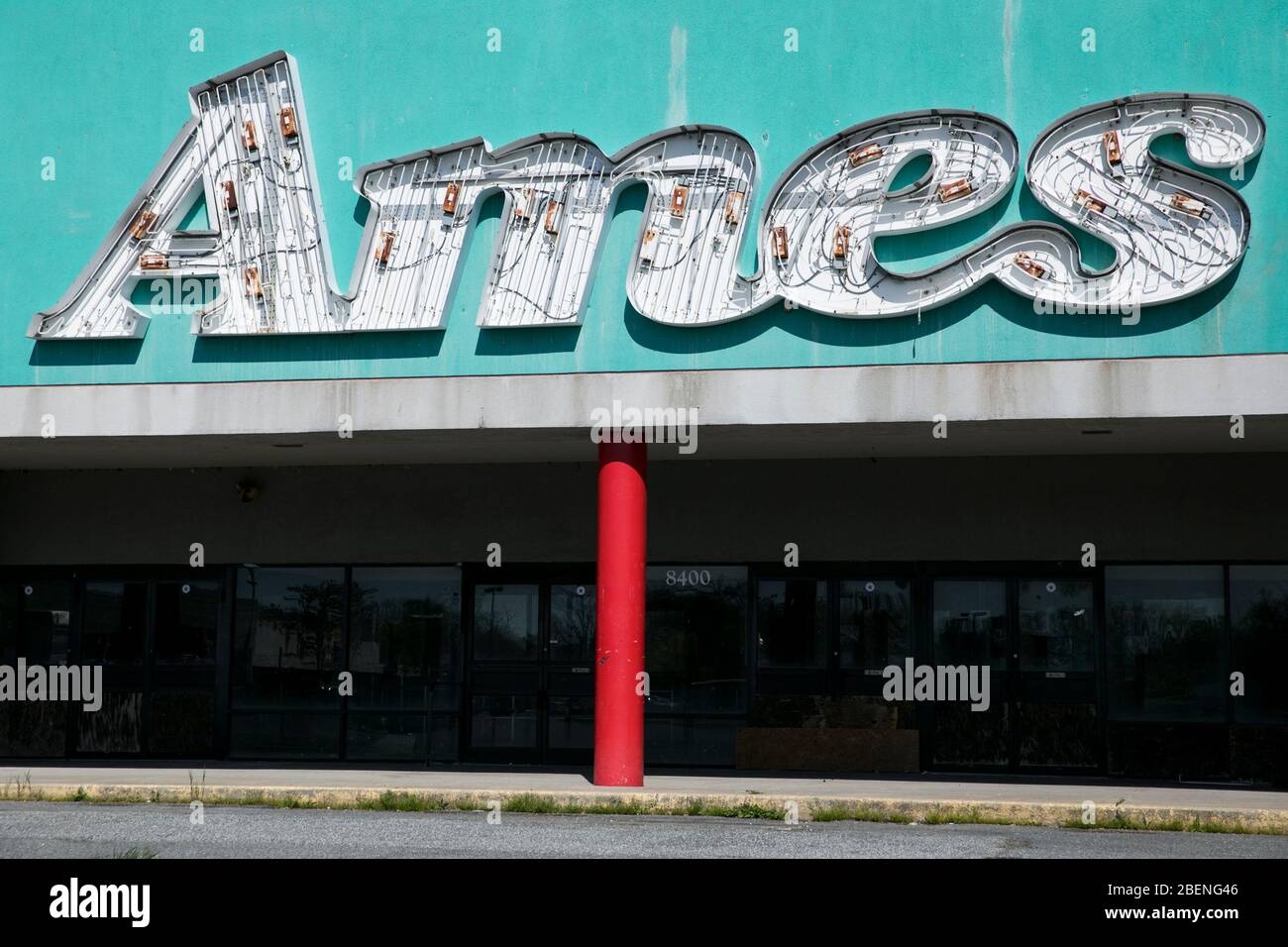 A logo sign outside of a closed and abandoned Ames Department Stores ...