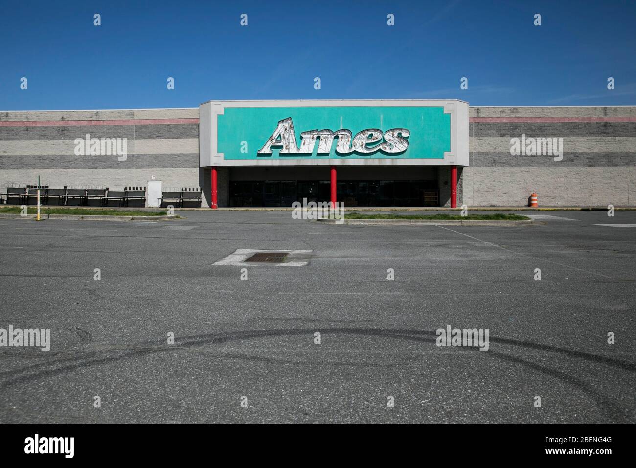 A logo sign outside of a closed and abandoned Ames Department Stores ...