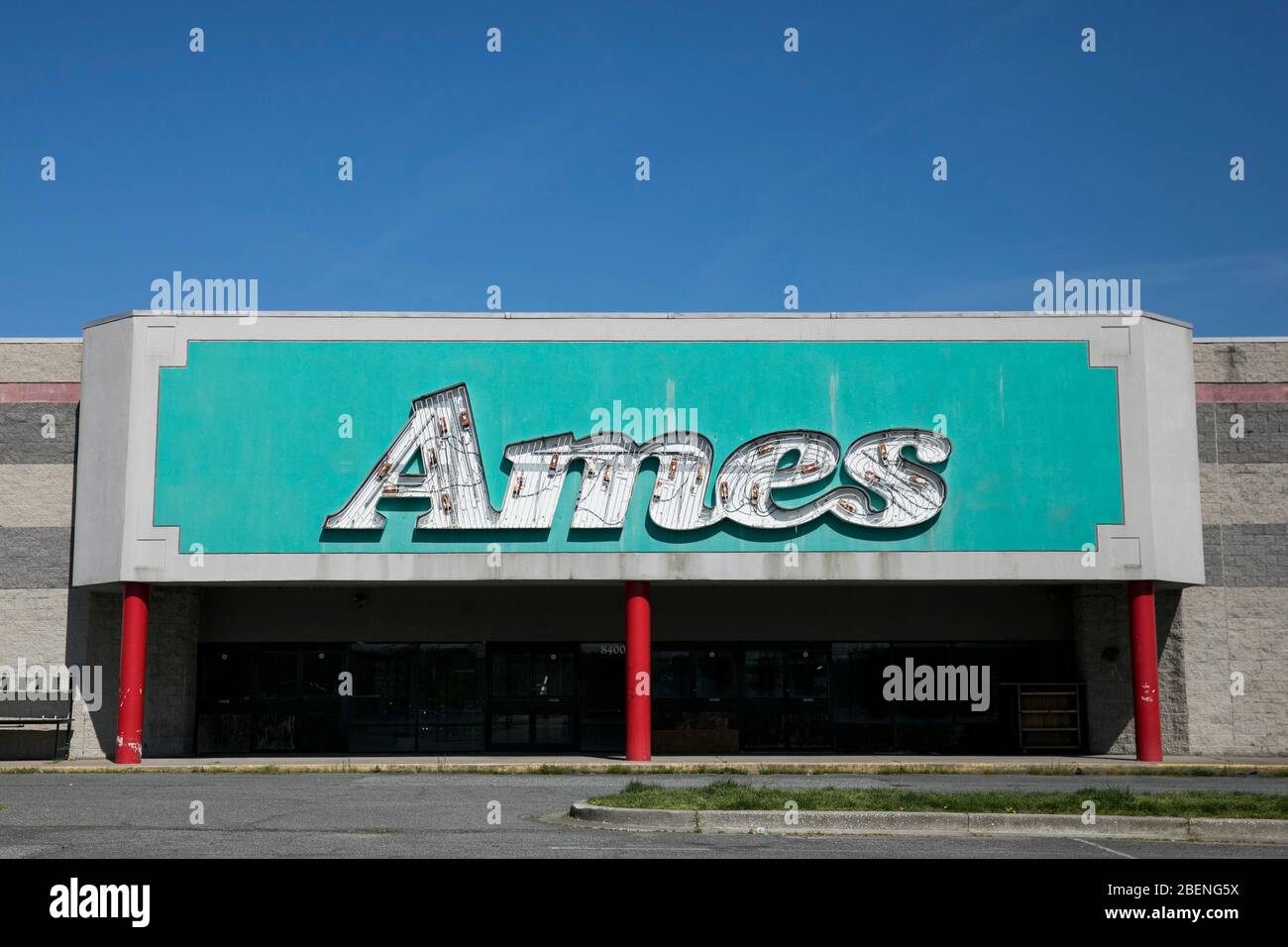 A logo sign outside of a closed and abandoned Ames Department Stores ...