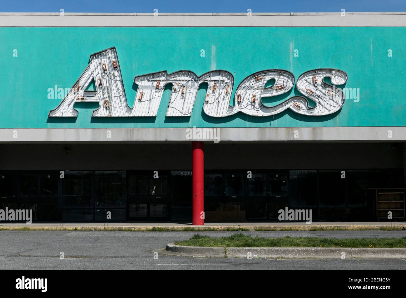 A logo sign outside of a closed and abandoned Ames Department Stores ...