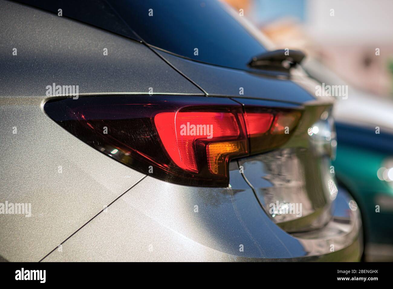 rear light of a parked car on the side of the street, vehicle exterior ...