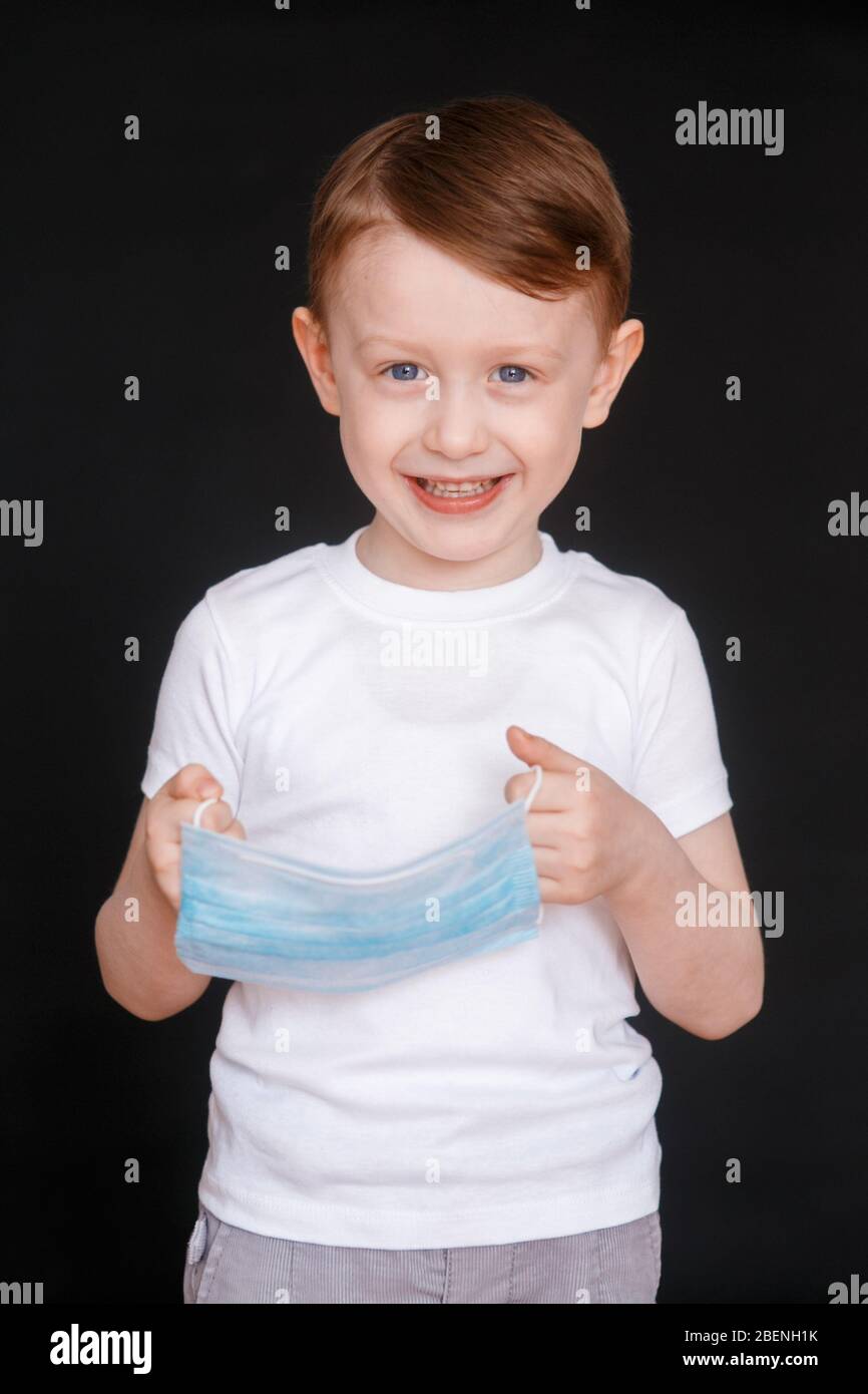 A little boy is holding a medical mask. Baby wears face masks covid-19 ...