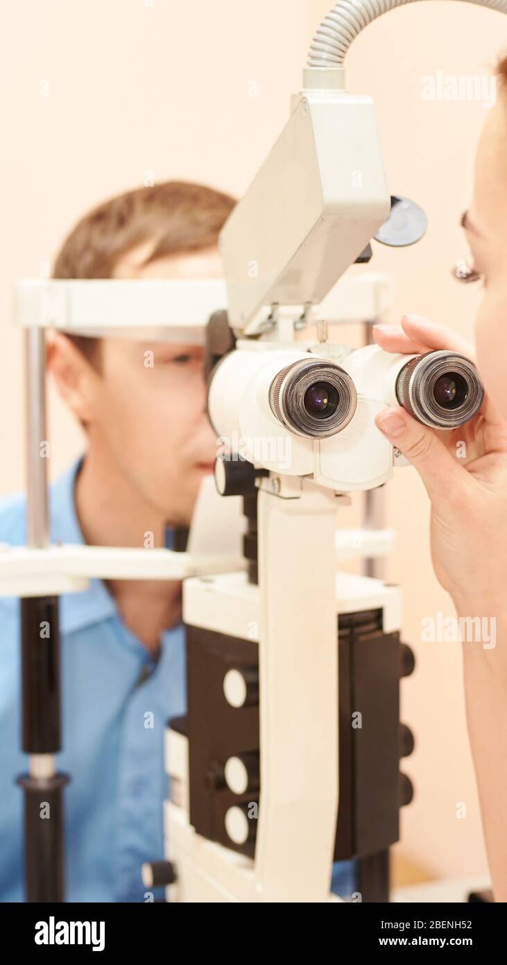ophthalmologist doctor in exam optician laboratory with male patient ...