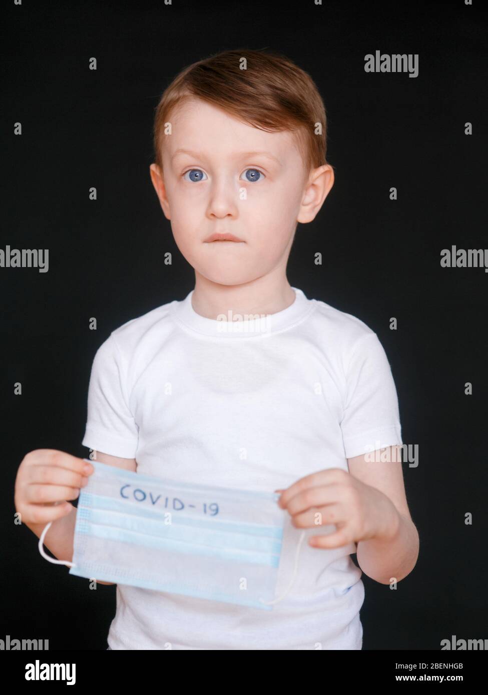 A little boy is holding a medical mask. Baby wears face masks covid-19 ...