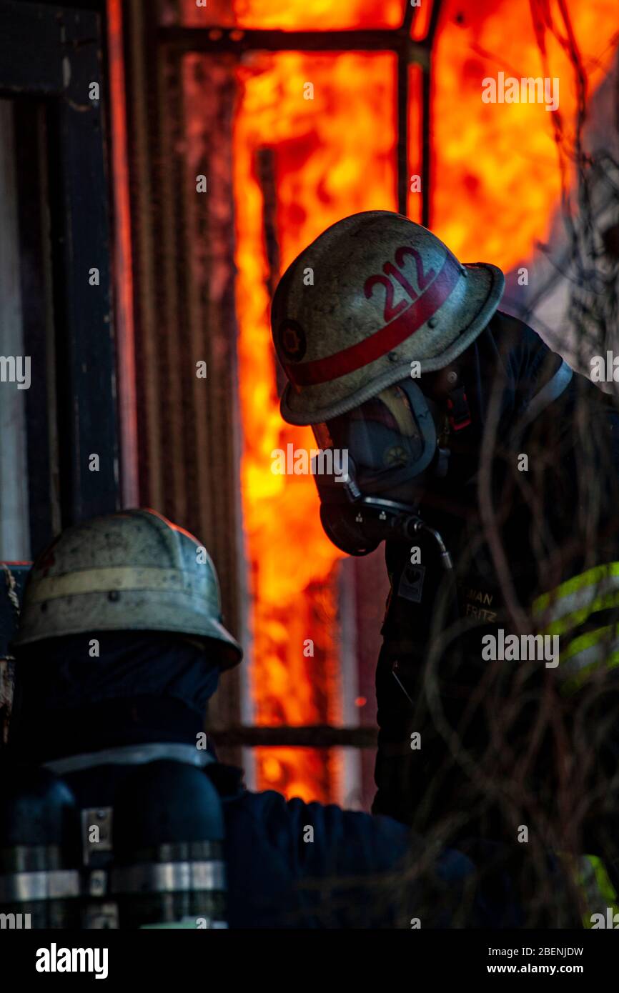 Firefighters trying to save burning house Stock Photo - Alamy