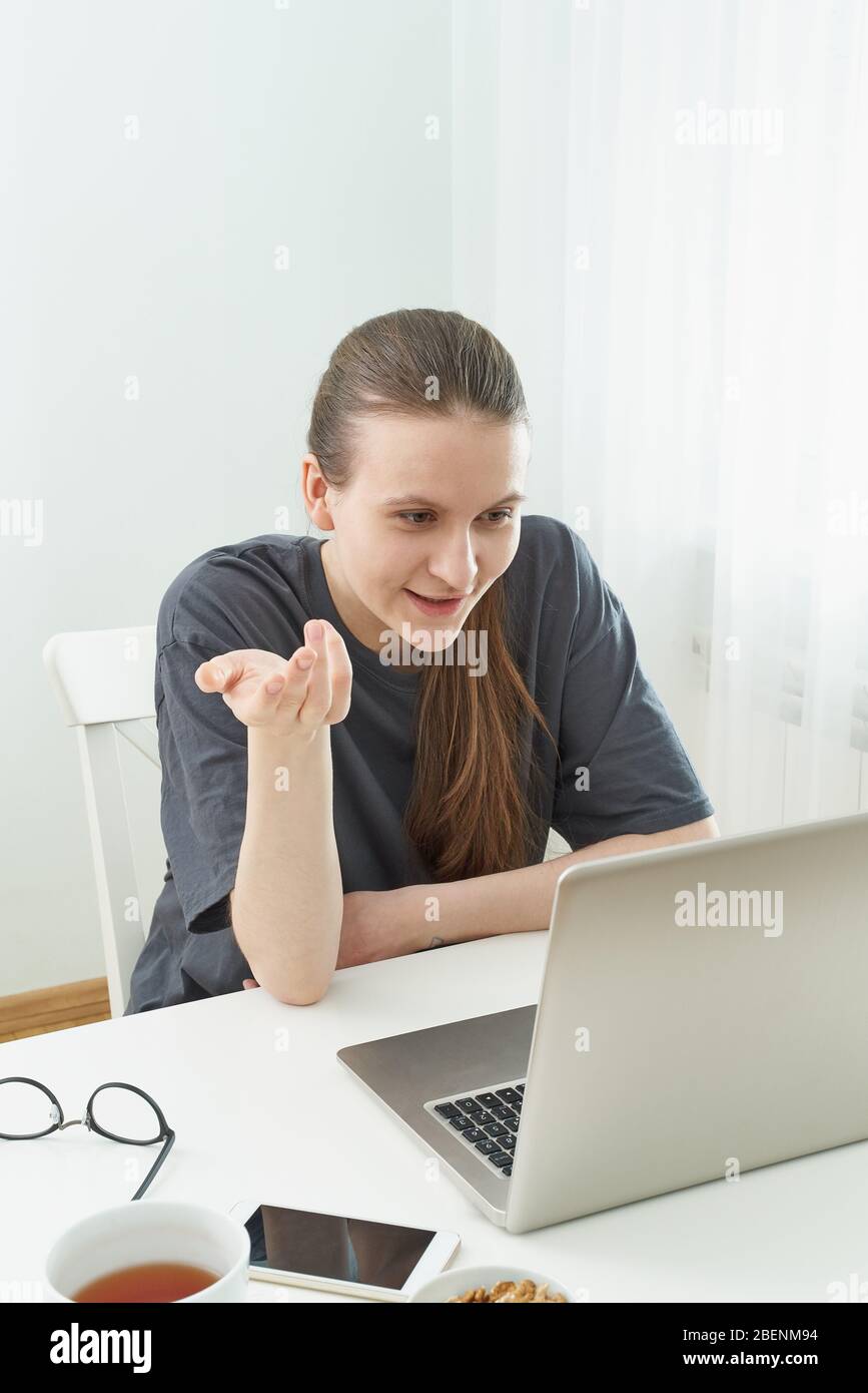Girl listens or looks at information on computer with disbelief ...