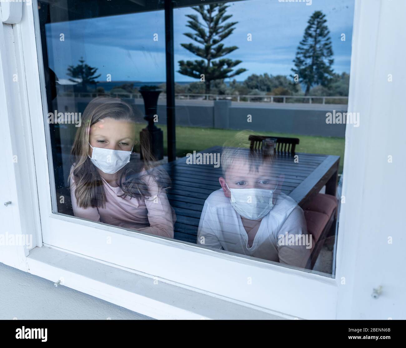 COVID-19 Lockdowns. Sad children with face mask looking through the ...