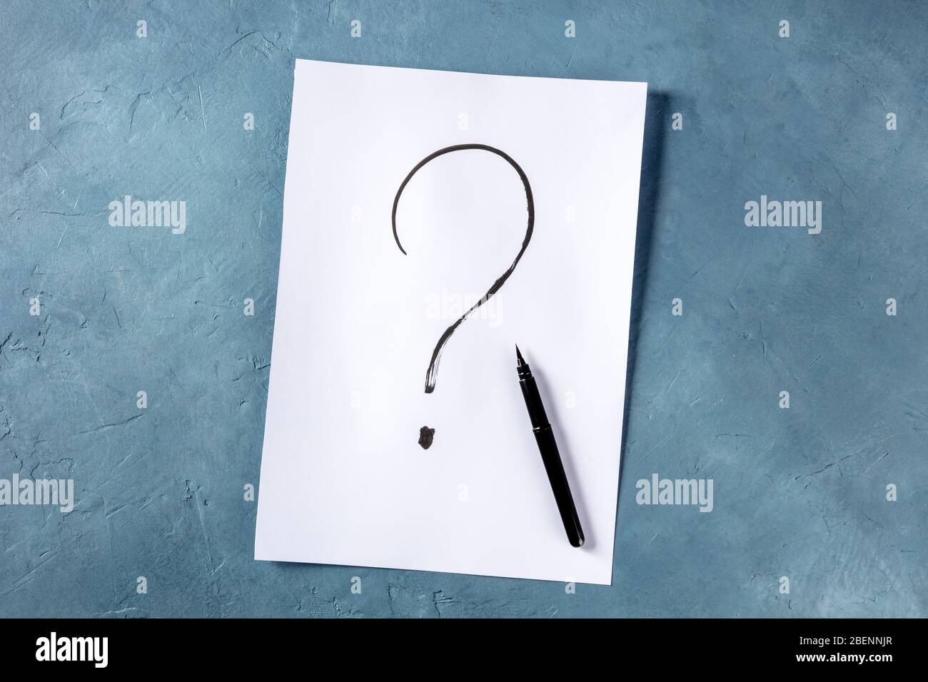 Question mark, written in ink on a piece of standard office paper, shot ...