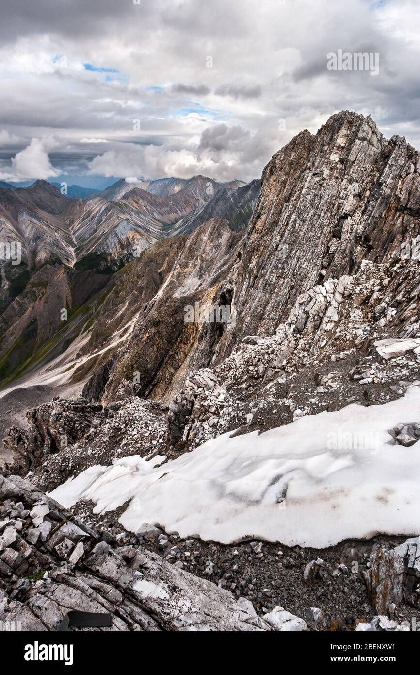 Bare rocks and mountains in the distance and the remains of old snow in ...