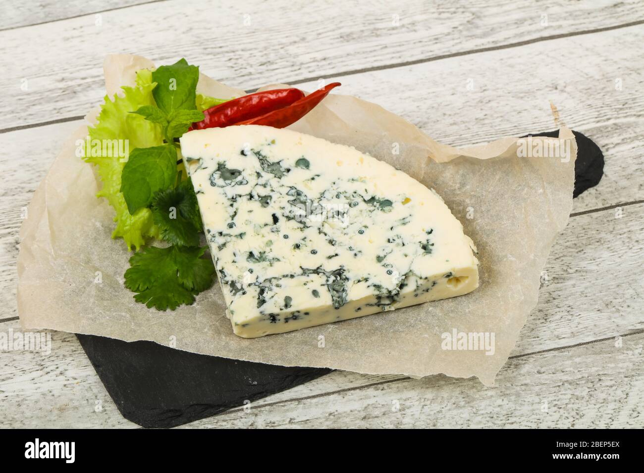 Blue cheese slice with salad leaves Stock Photo - Alamy