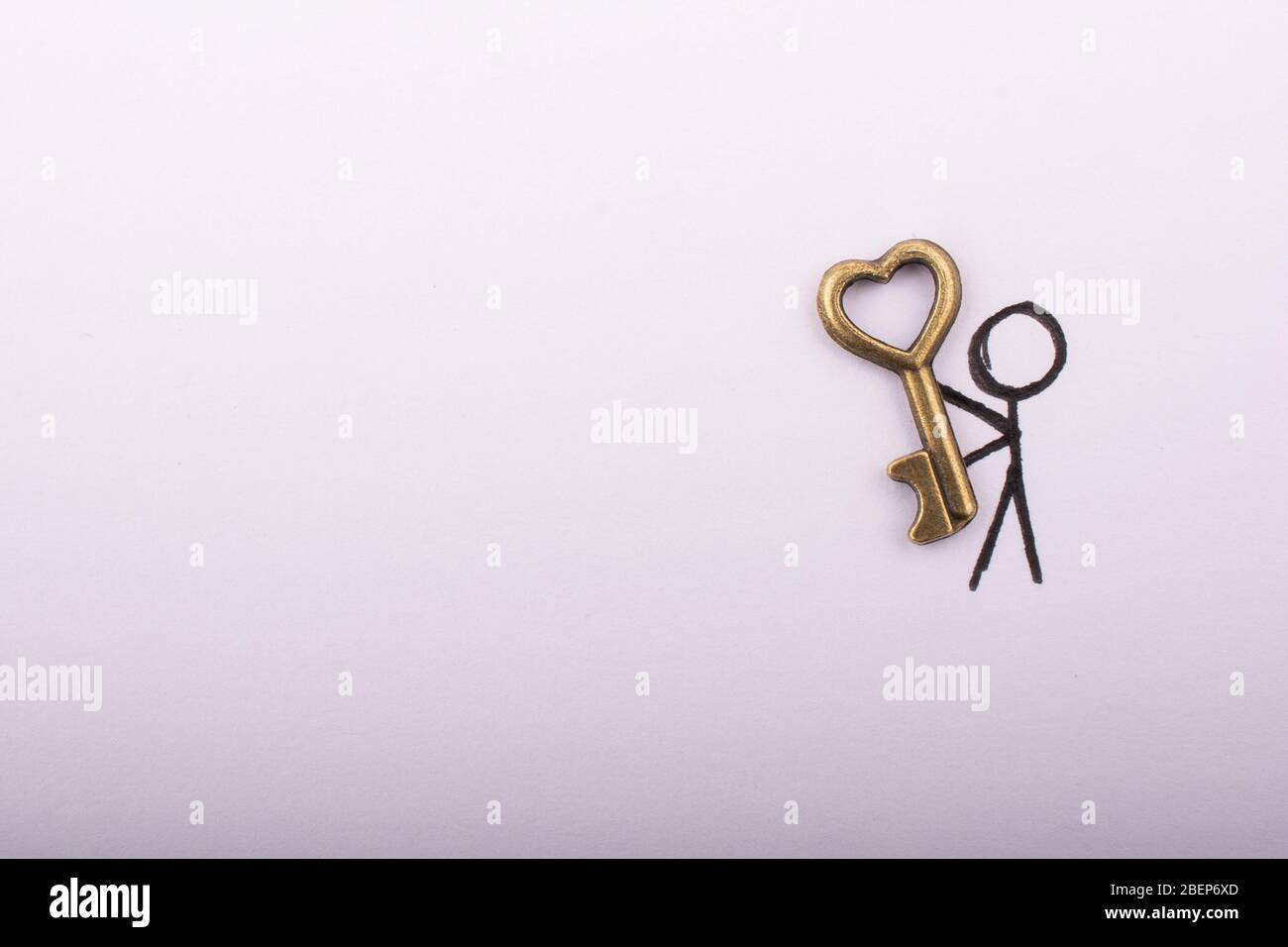 Man carrying a heart shaped key on white background Stock Photo - Alamy