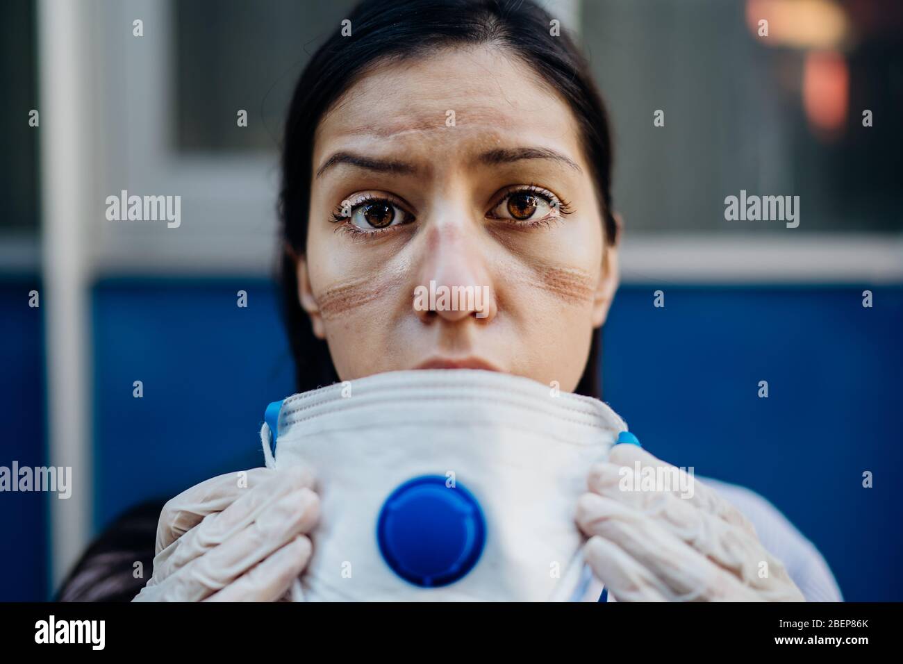 Exhausted doctor / nurse taking of coronavirus protective gear N95 mask ...