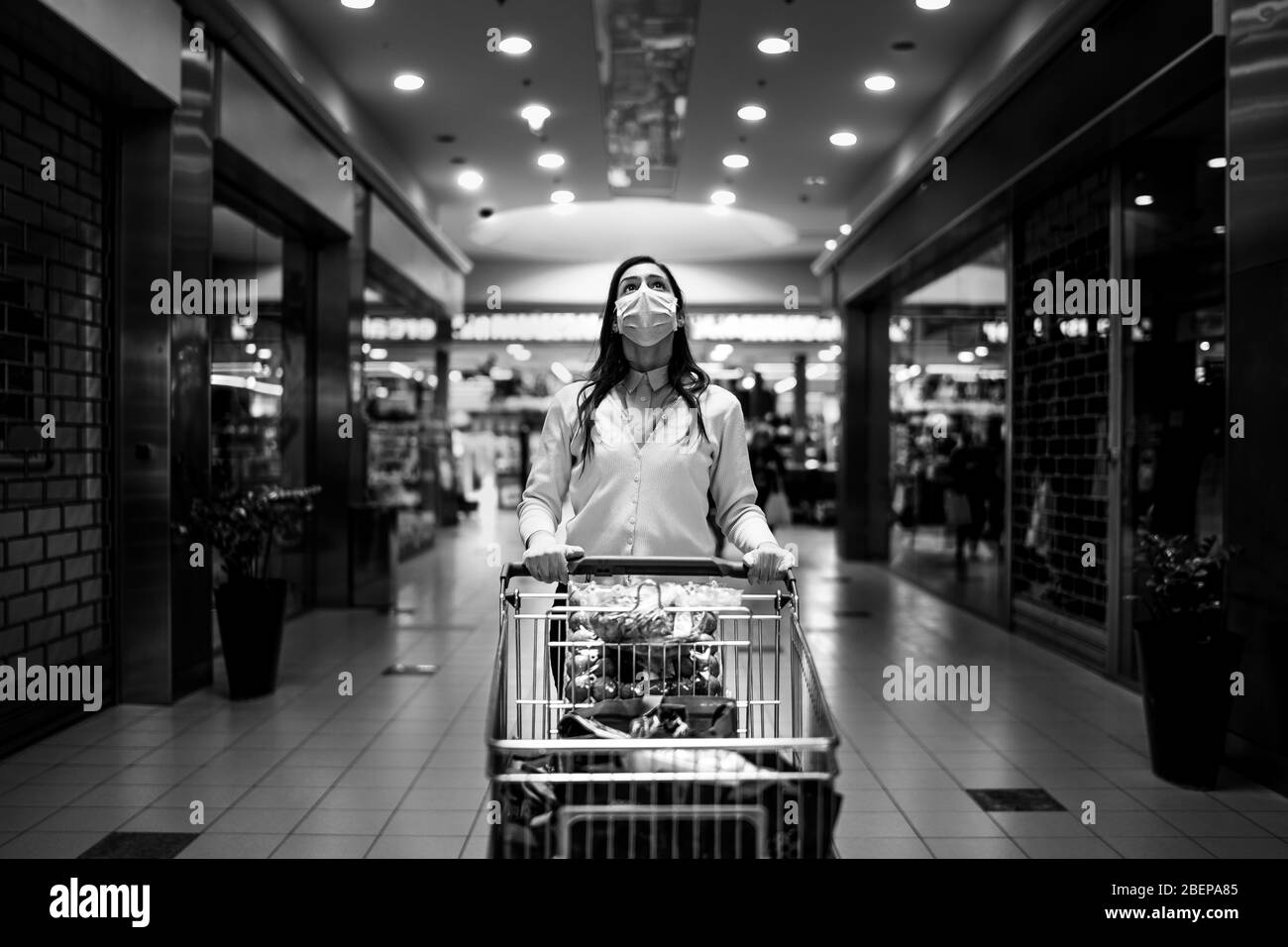 Worried woman with mask groceries shopping in supermarket,pushing ...