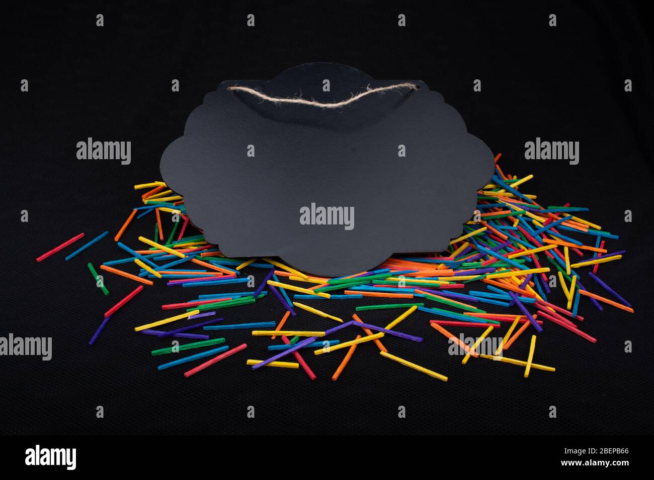 Black speech bubble shaped notice board on colorful sticks on black ...