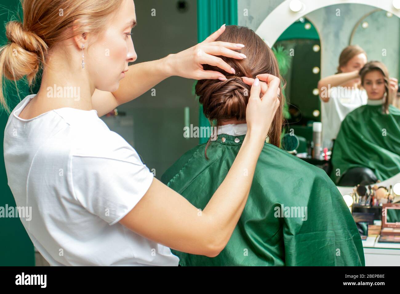 Hairdresser is making hairstyle of woman in beauty salon Stock Photo ...