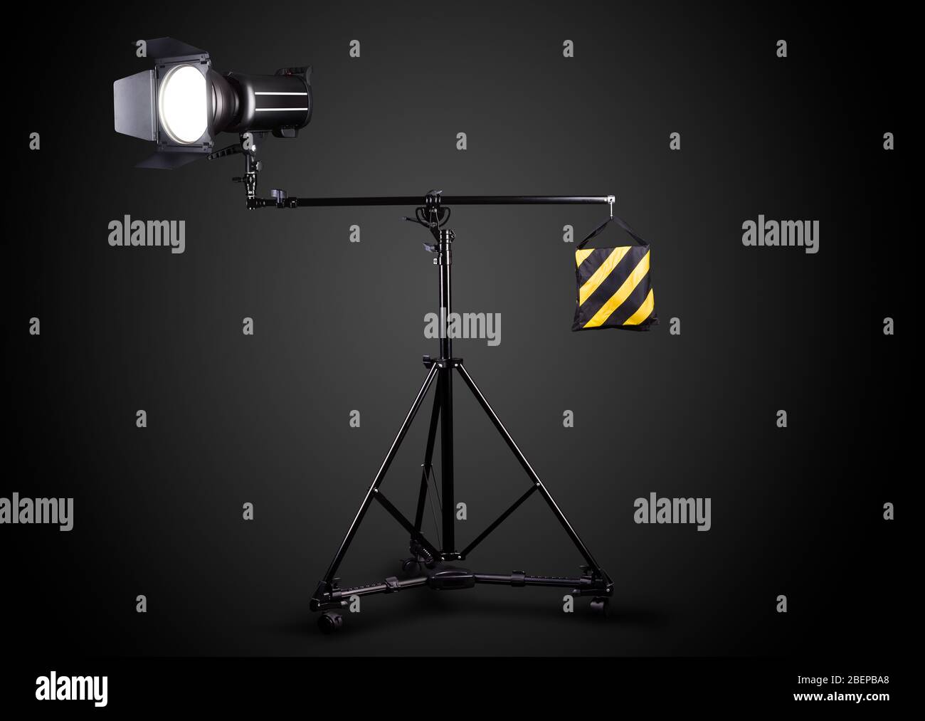 Photography studio flash on a lighting stand isolated on black ...