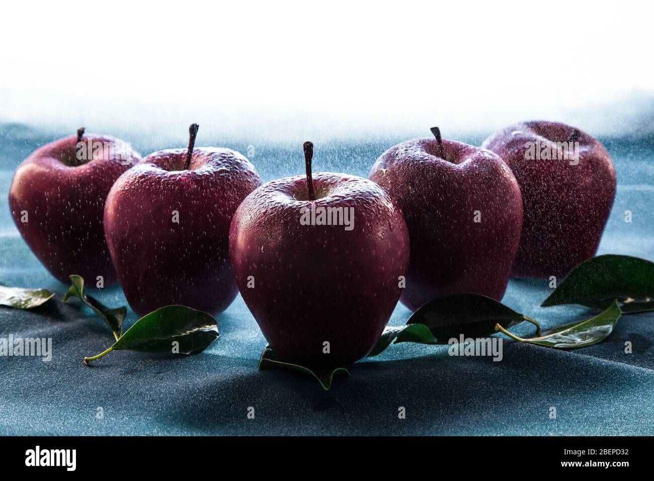 Red apples with leaves and falling water drops. Raindrops falling on ...