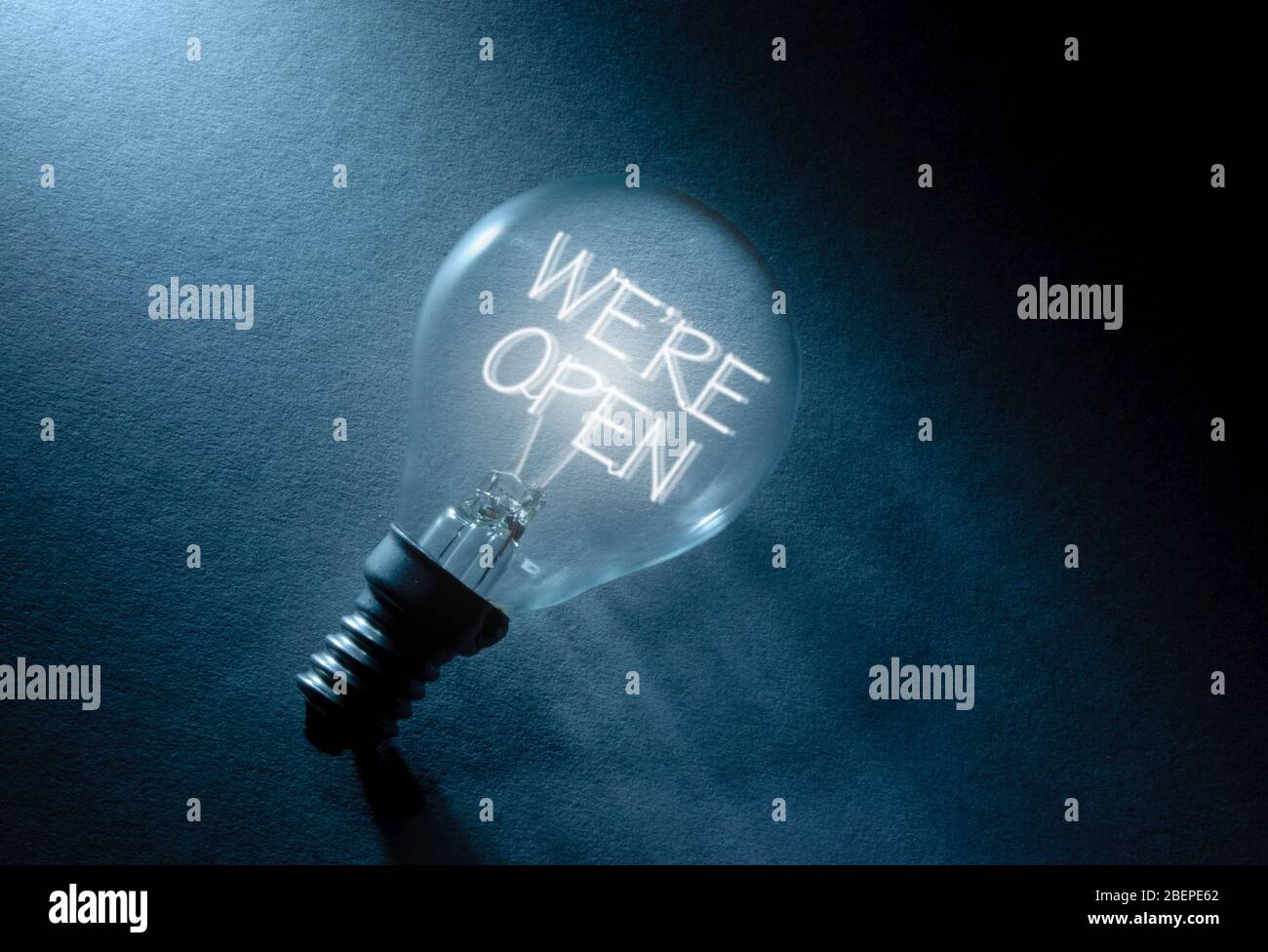 Light bulb illuminating the word we're open Stock Photo - Alamy