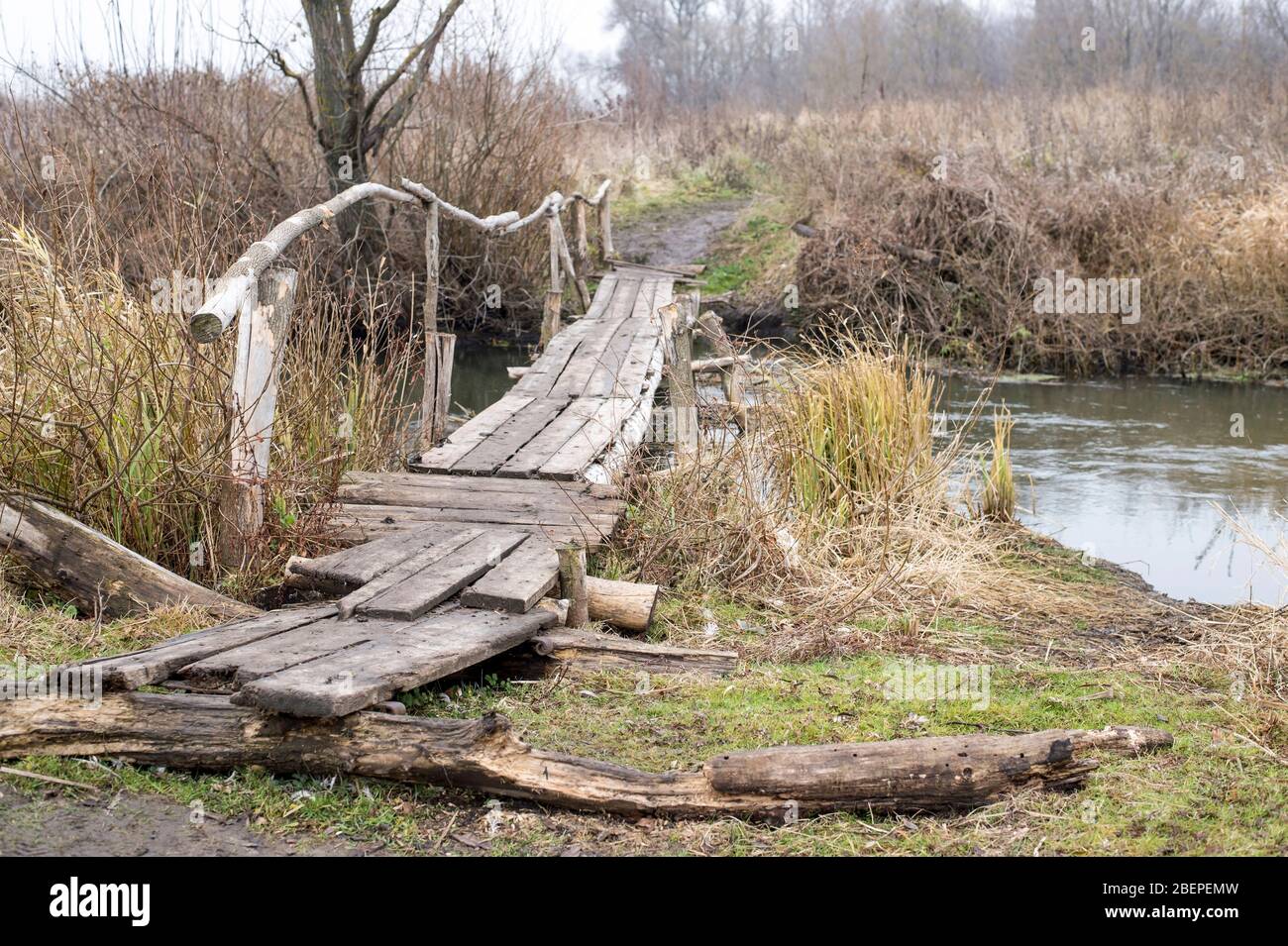 Wooden bridge over a small river in the village in autumn. Background ...